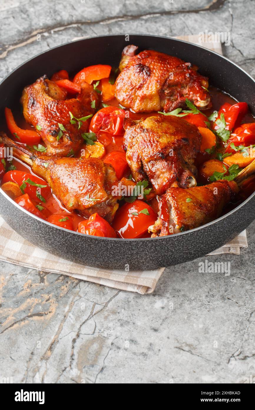 Homemade rooster cooked with vegetables in tomato sauce close-up in a ...