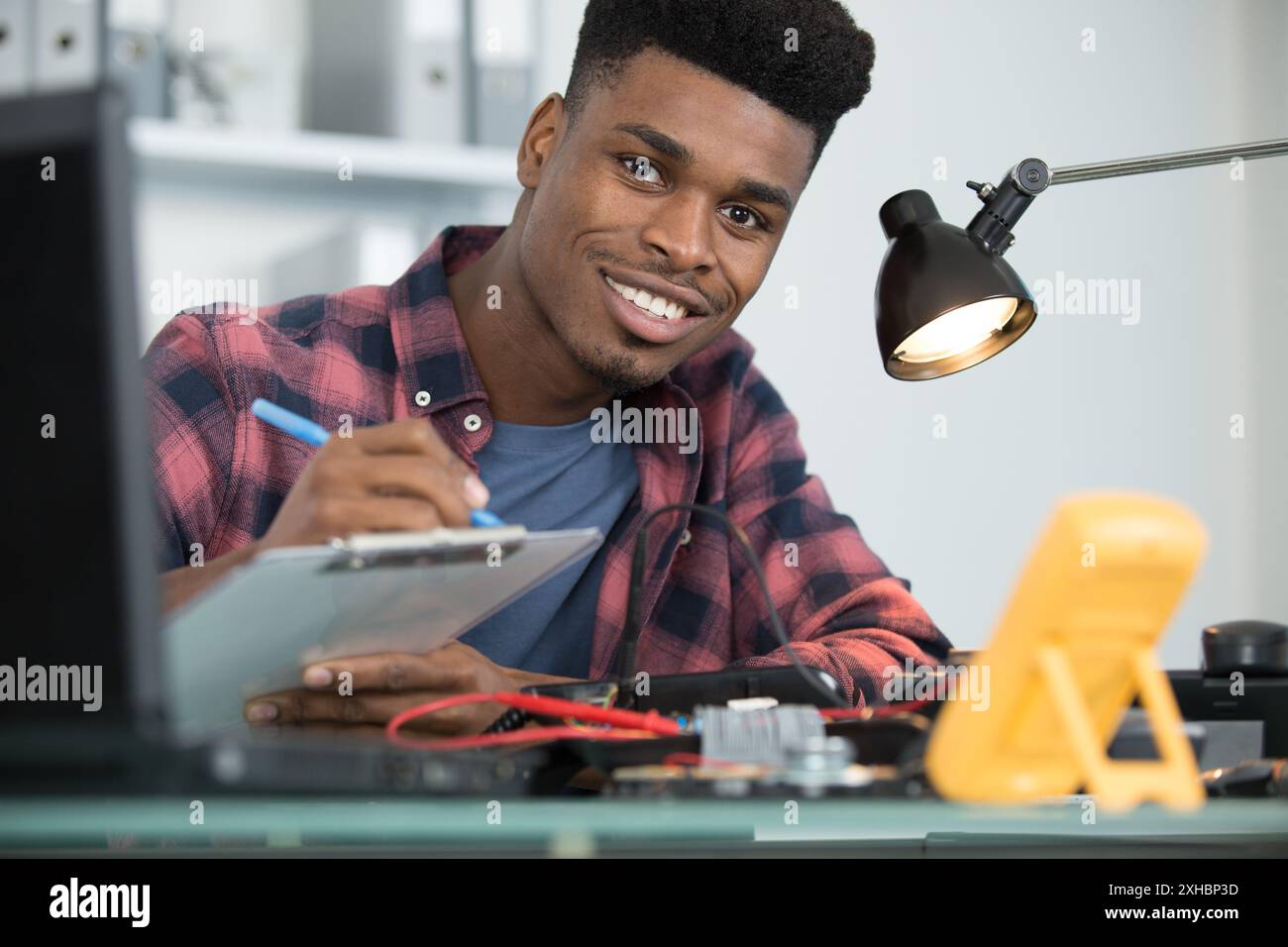 engineer taking notes while fixing a computer Stock Photo - Alamy