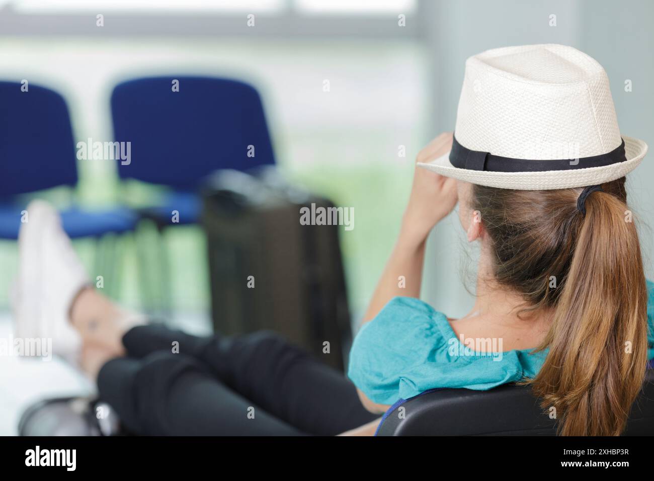 Woman sit in airport waiting hi-res stock photography and images - Alamy