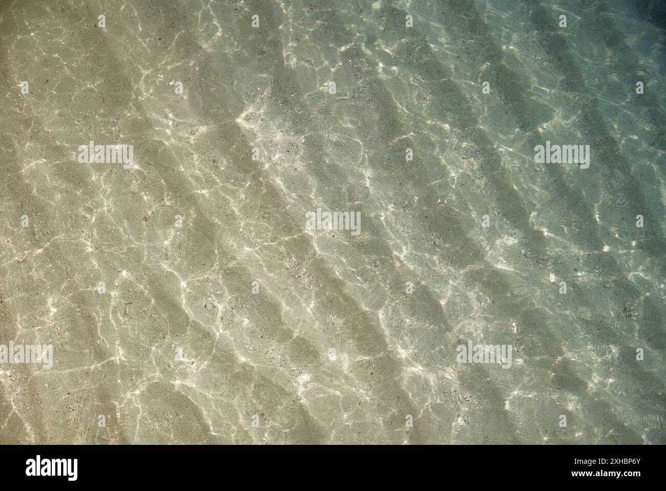 The clear shallow water with sunlight reflections at Ellaidhoo ...