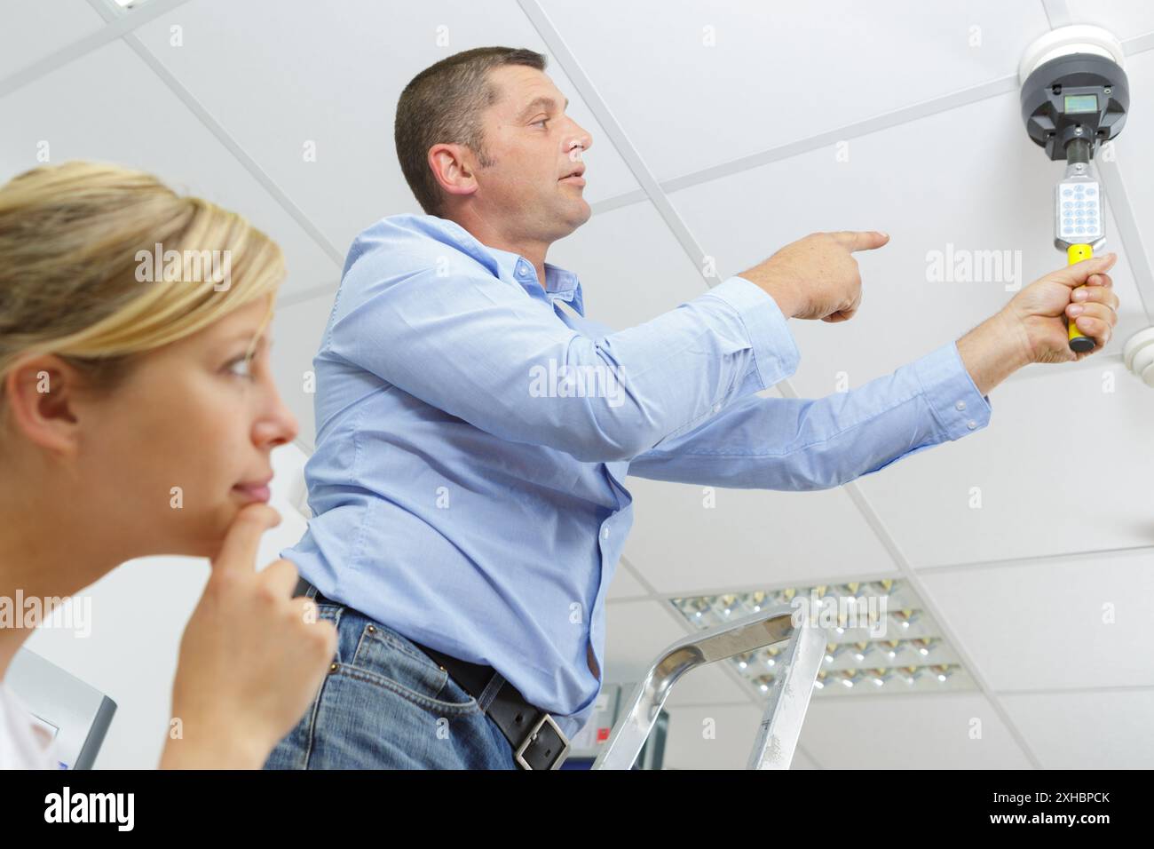 man testing the fire prevention system on ceiling Stock Photo - Alamy