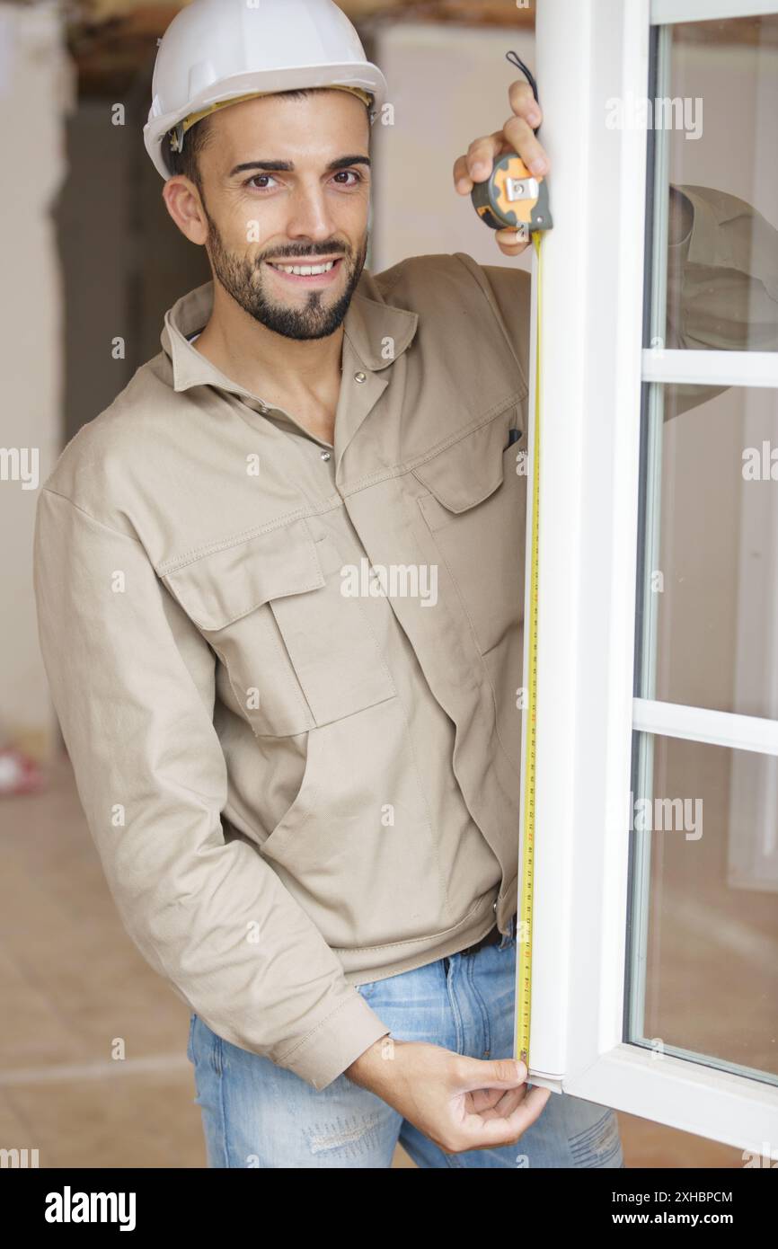 builder measuring a window using a tape measure Stock Photo - Alamy