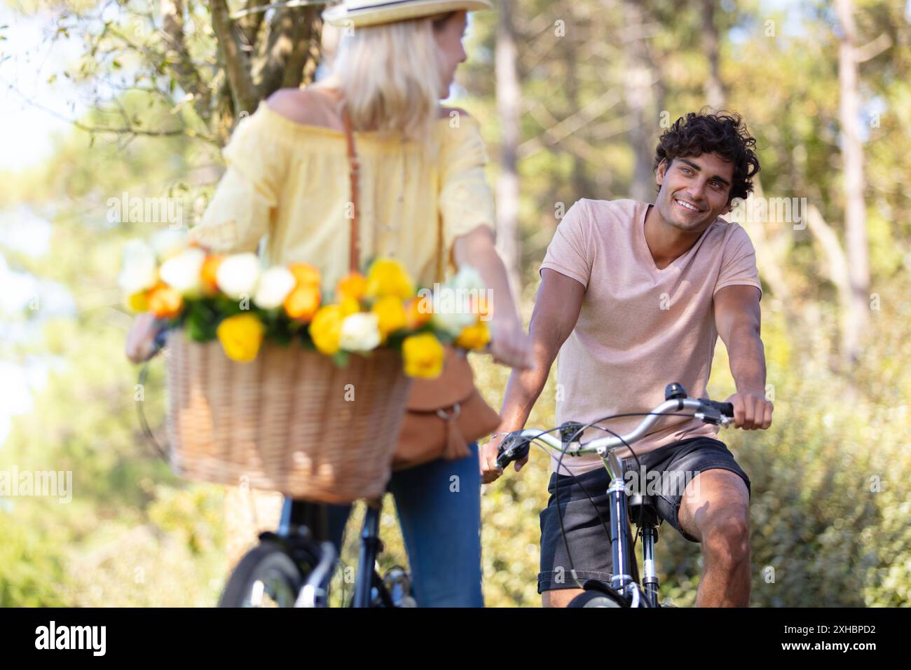 happy couple chasing each other on bike Stock Photo - Alamy