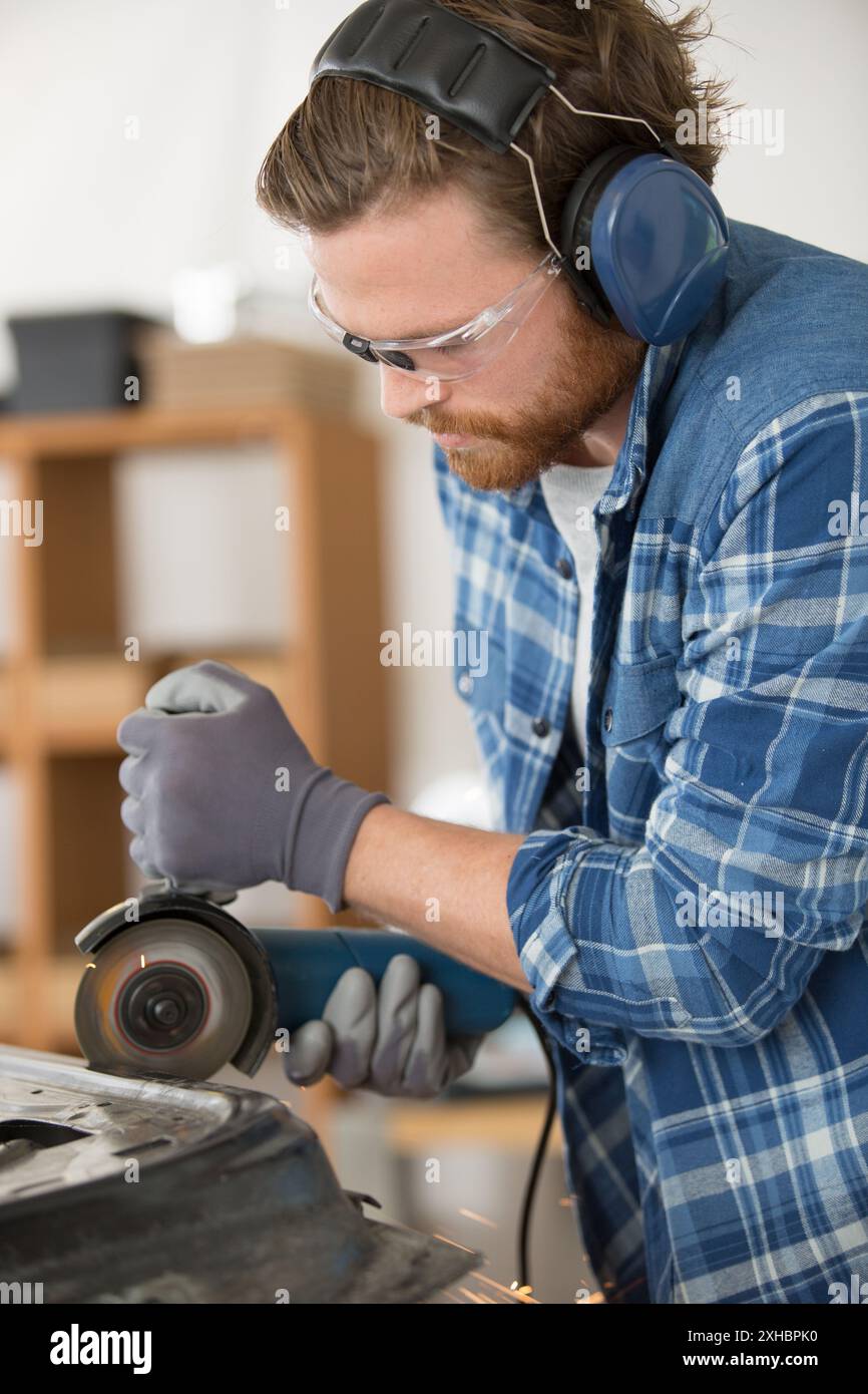 male worker using an angle grinder Stock Photo - Alamy