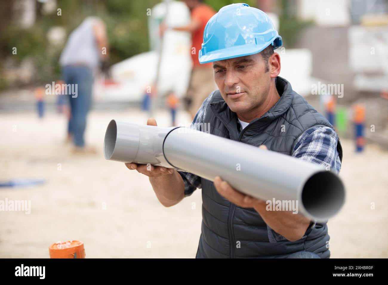 happy hispanic construction worker with pipe at building site Stock ...