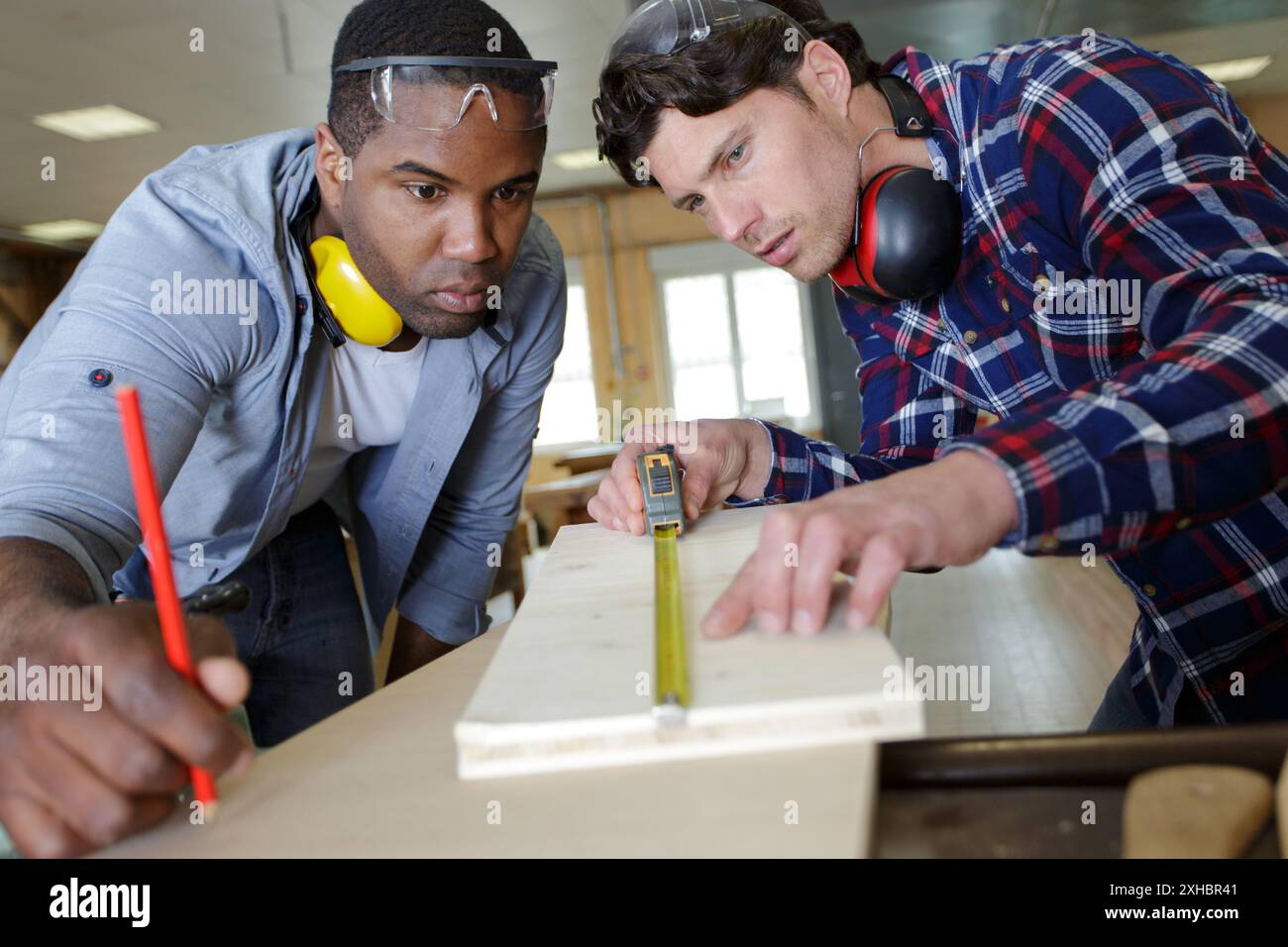 two carpenters with ruler measuring wood plank at workshop Stock Photo ...