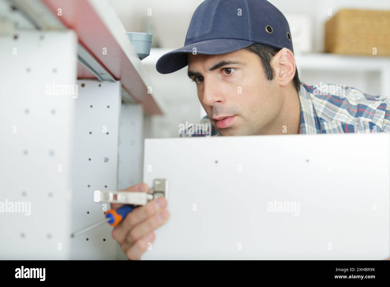 man is fixing a wood cupboard Stock Photo - Alamy