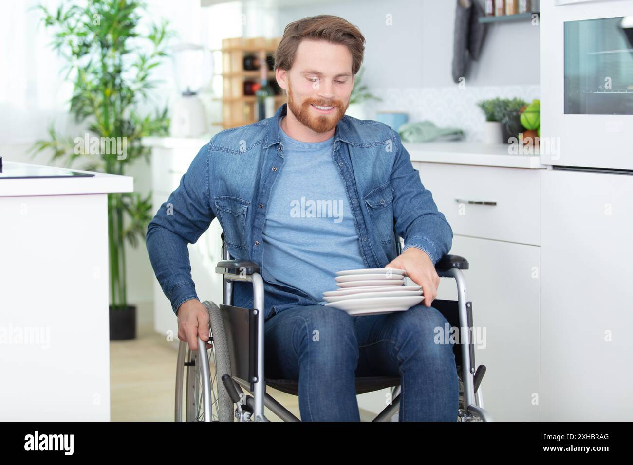 young happy disabled man sitting on wheelchair with plates Stock Photo ...