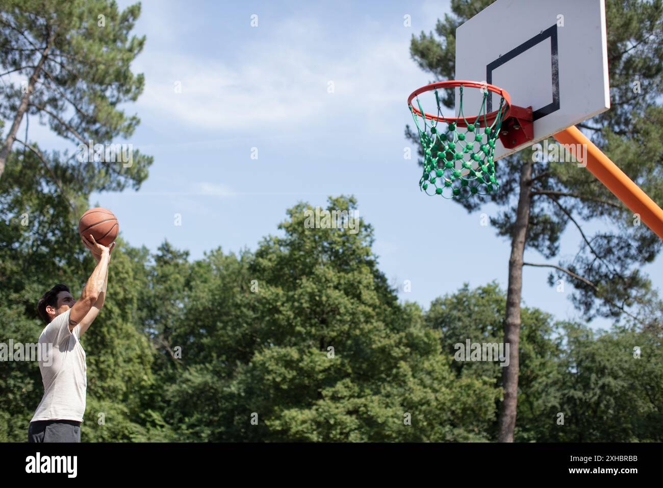 basketball player taking a jump shot at basketball court Stock Photo ...