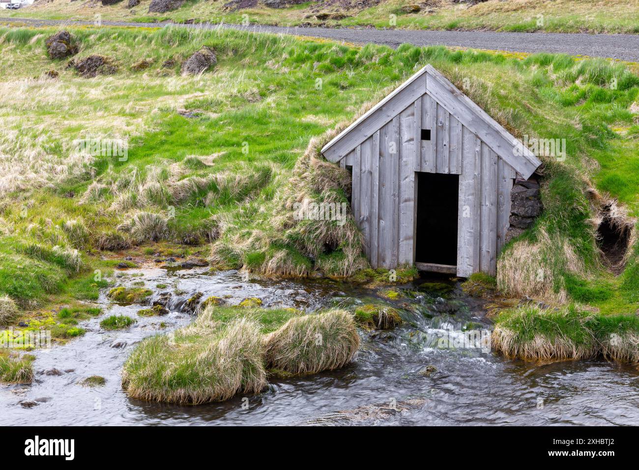 Icelandic Elf turf house (alfhol) by the river, overgrown with grass ...
