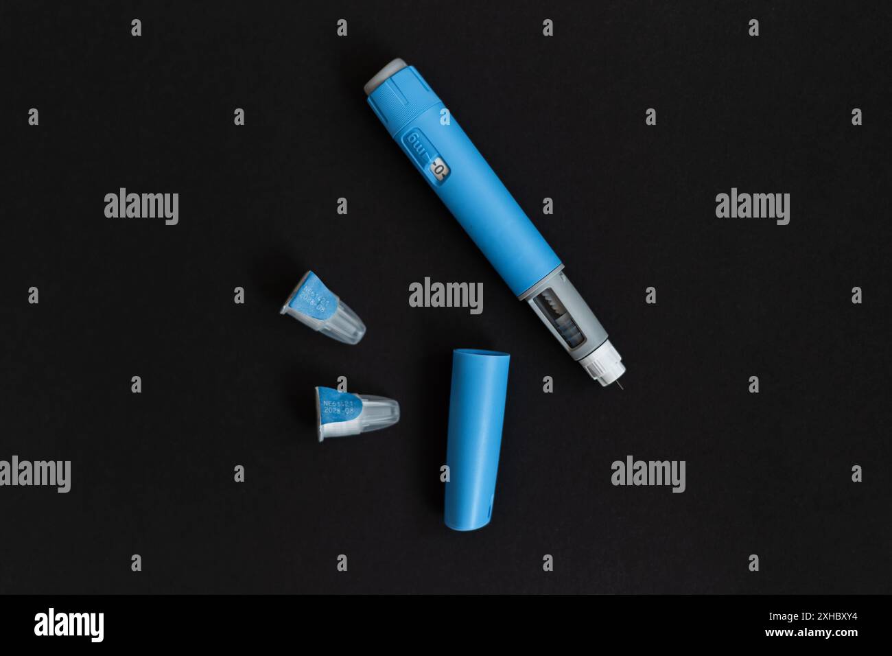 Blue medical drug anti diabetes injector with needles lies on a black ...