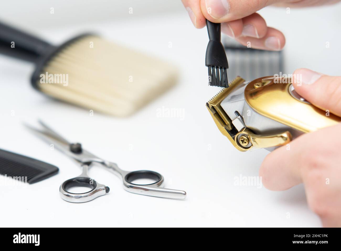 Barber cleaning a hairclipper brushing hair trimmer Stock Photo - Alamy