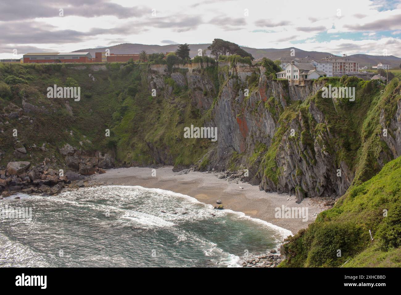 some houses near a cliff in front of a beach in Luarca, Spain Stock ...
