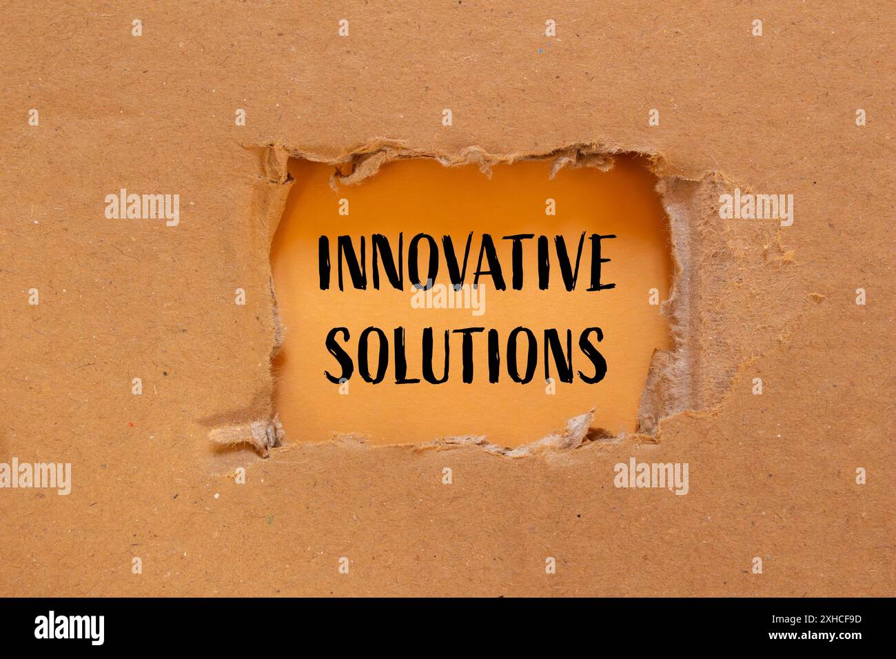Innovative solutions message written on ripped cardboard paper with ...