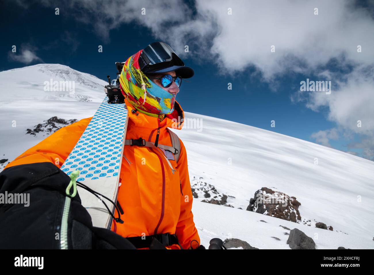 Wide angle shot young tall professional skier holds his skis while ...
