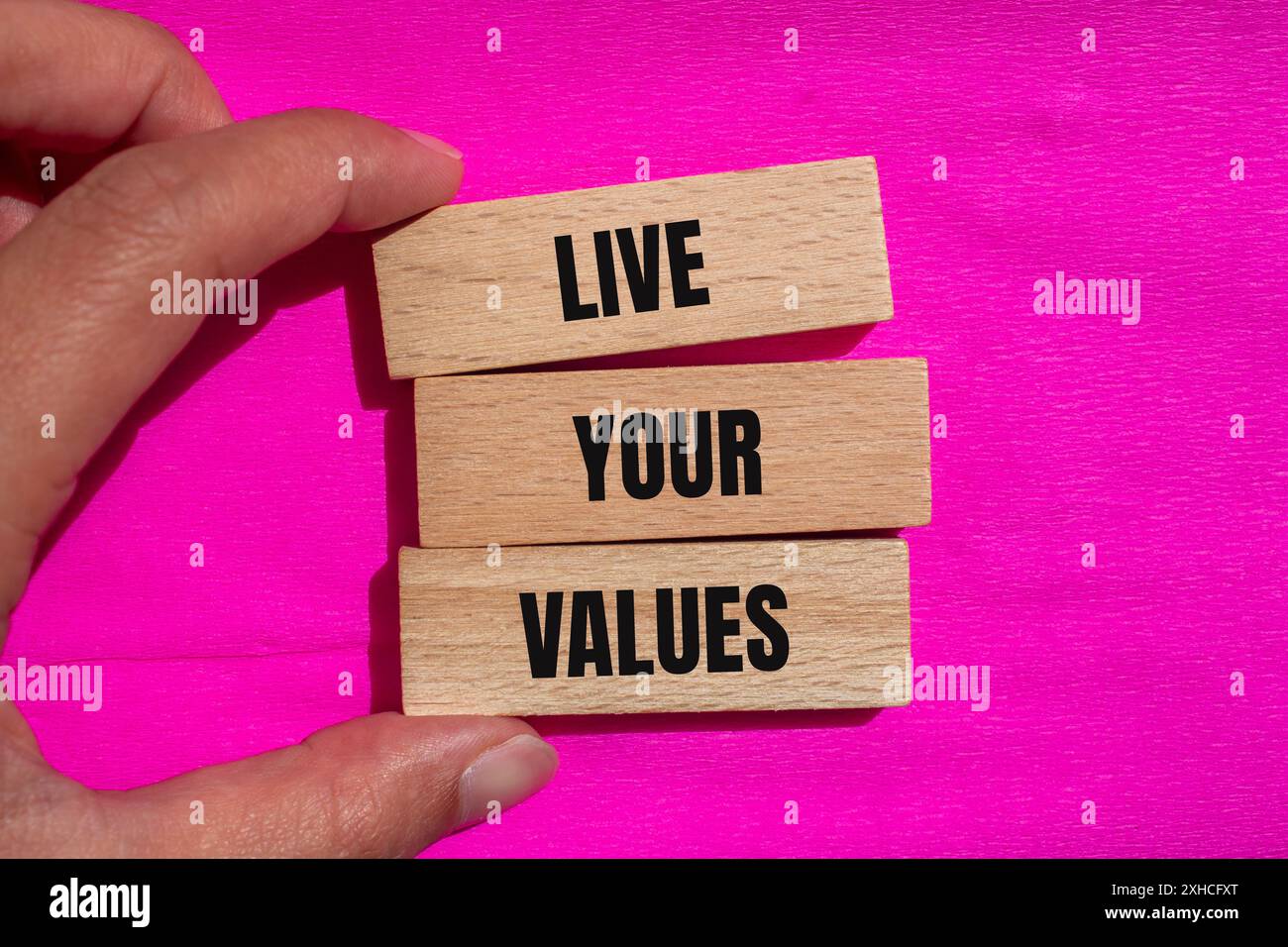 Live your values words written on wooden blocks with pink background ...