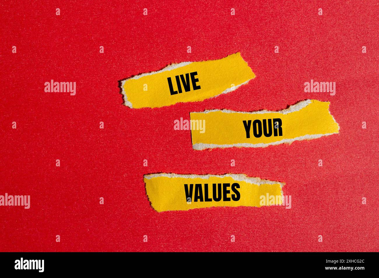 Live your values words written on ripped yellow paper pieces with red ...