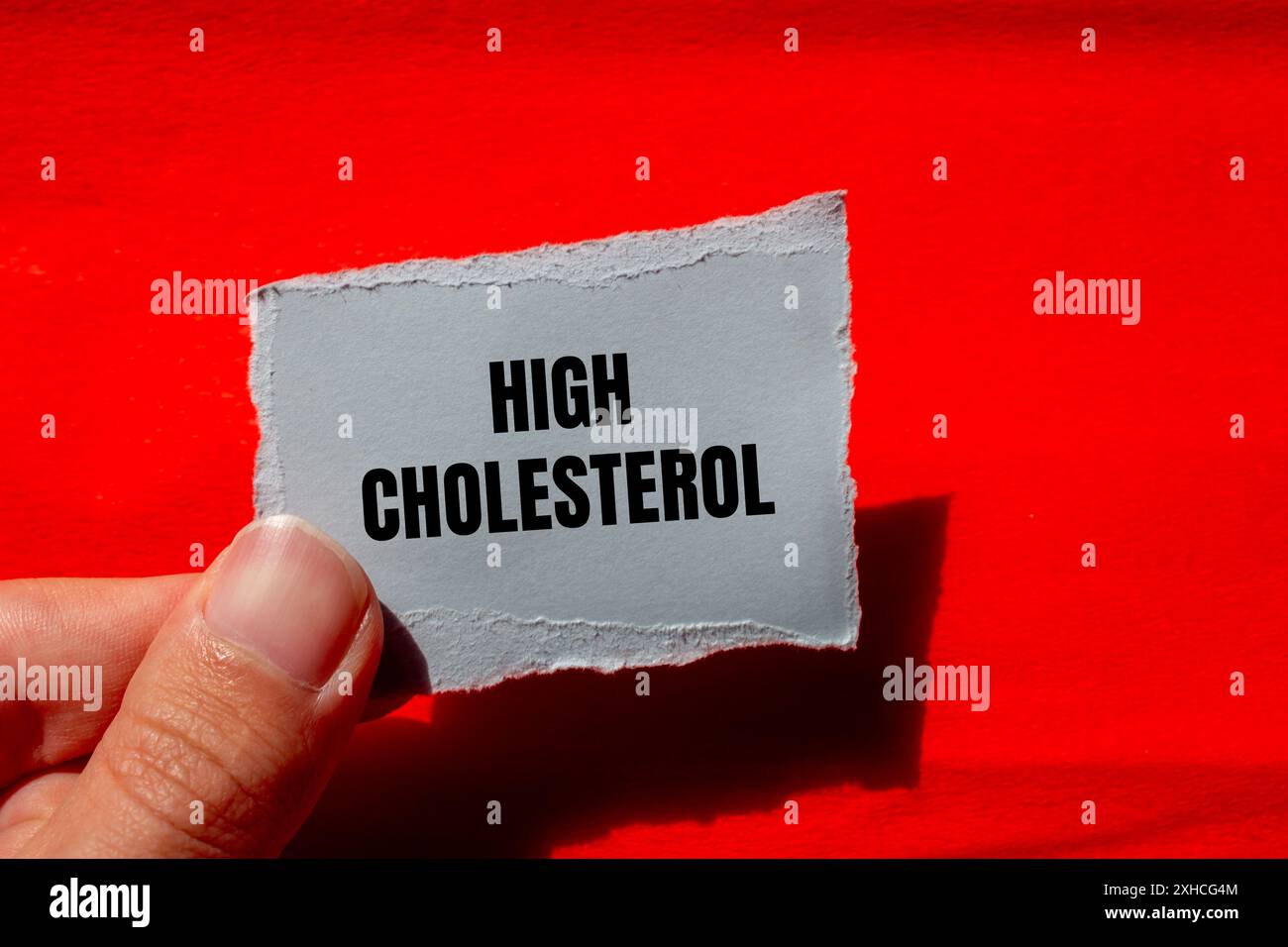 High cholesterol message written on ripped paper piece with red ...