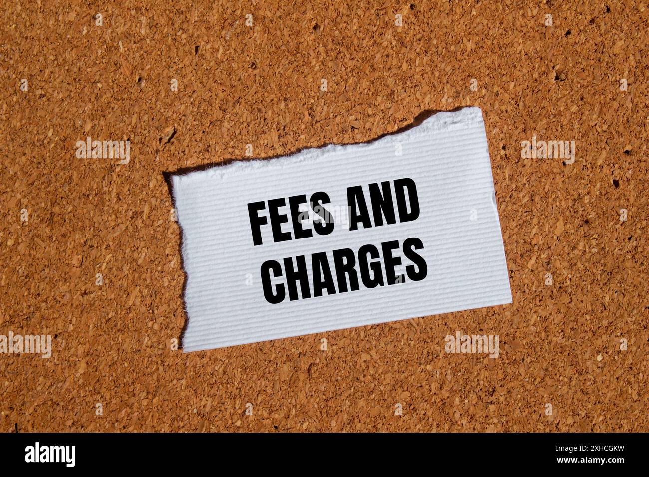 Fees and charges words written on ripped white paper with brown ...