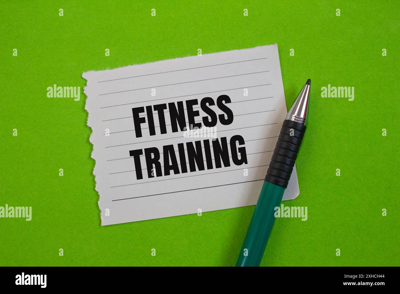 Fitness training message written on ripped paper piece with ...