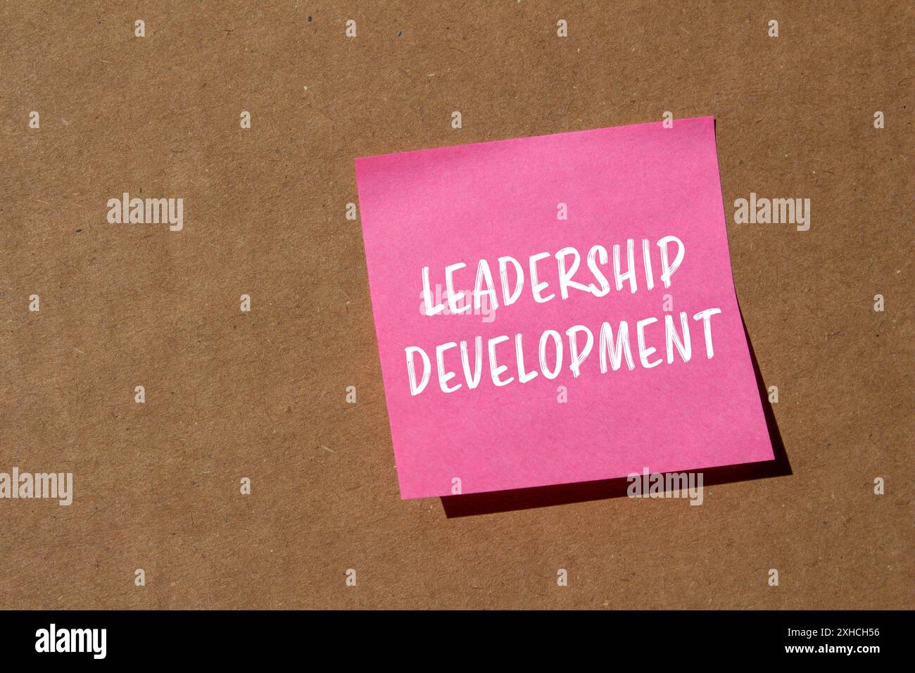 Leadership development message written on pink paper with cardboard ...