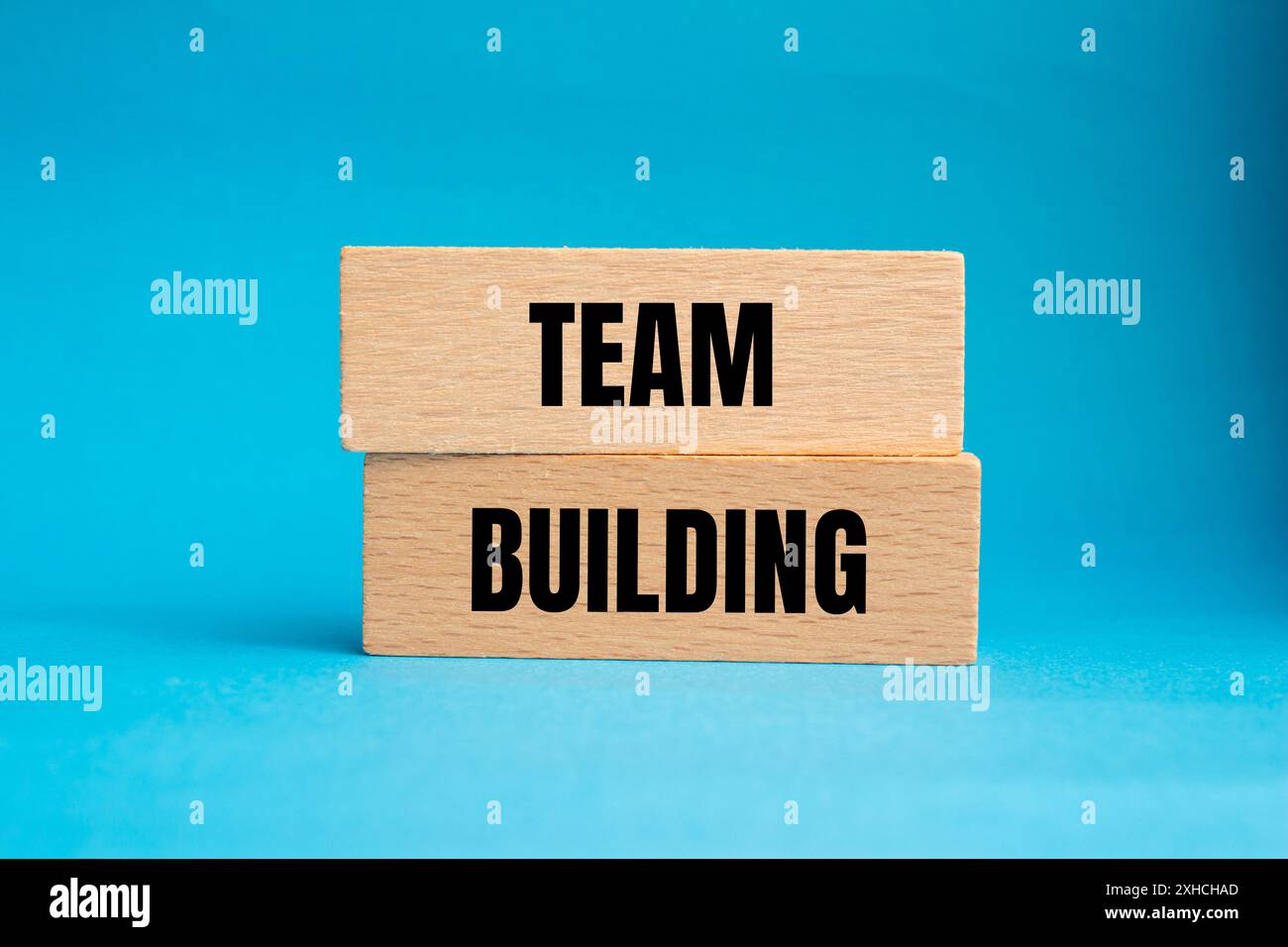 Team building message written on wooden blocks with blue background ...