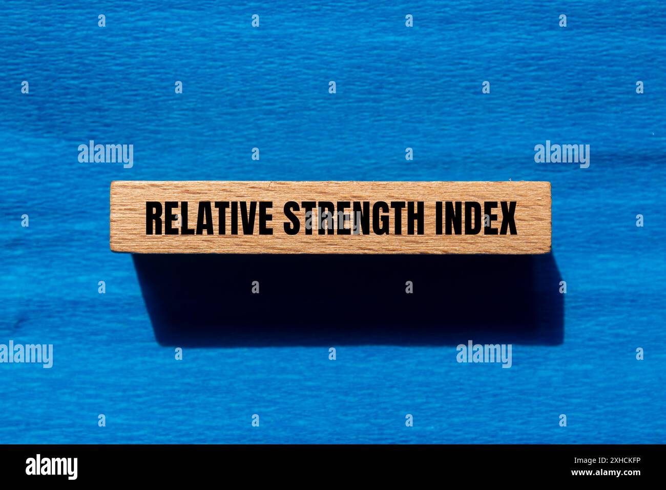 Relative strength index message written on wooden block with blue background. Conceptual ...