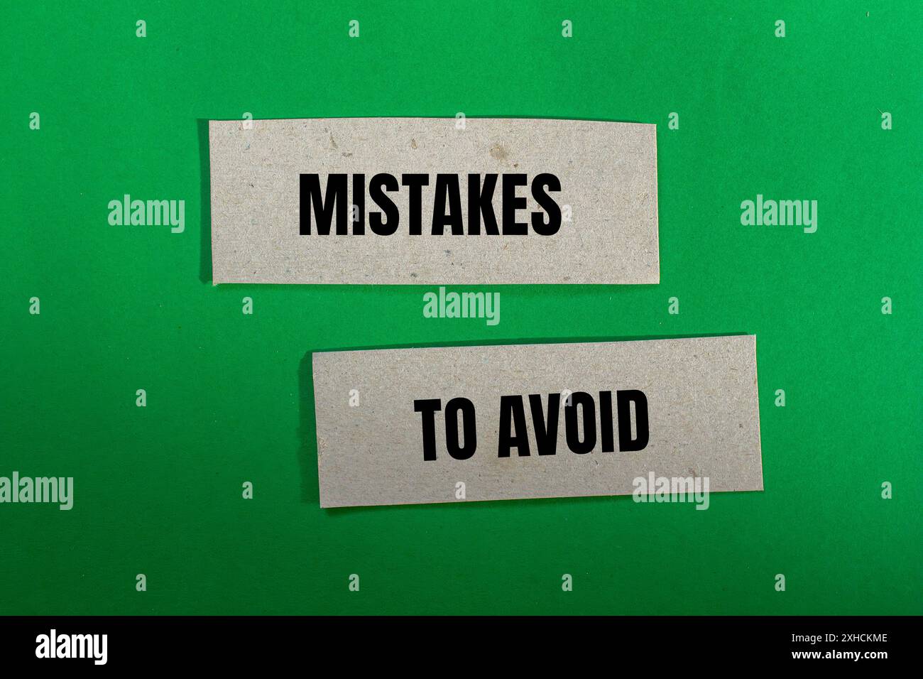 Mistakes to avoid message written on paper pieces with green background ...
