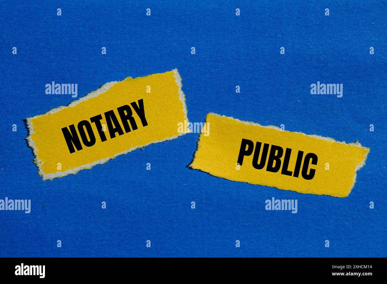 Notary public words written on ripped yellow paper pieces with blue ...