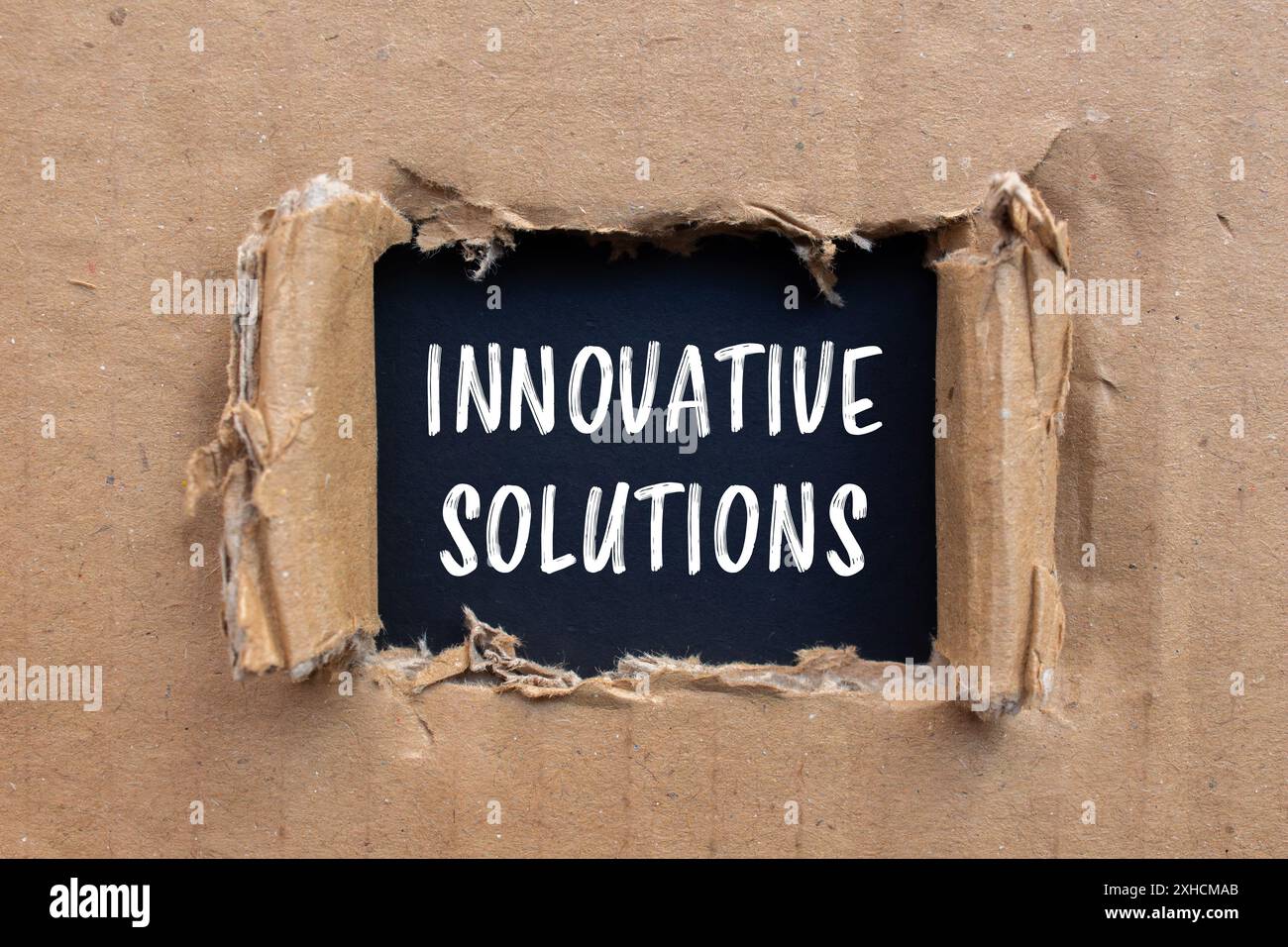 Innovative solutions message written on ripped cardboard paper with ...