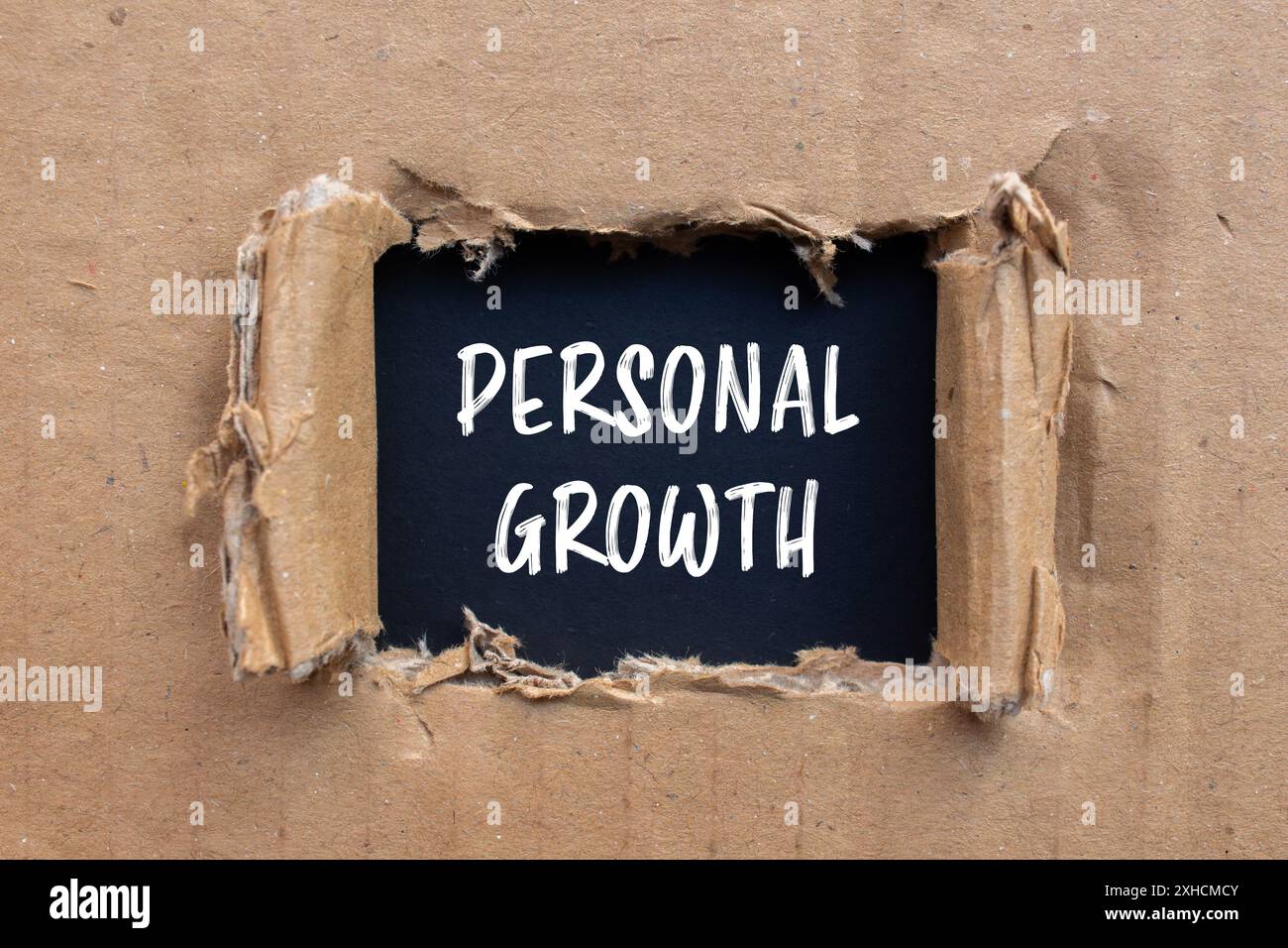Personal growth message written on ripped cardboard paper with black ...