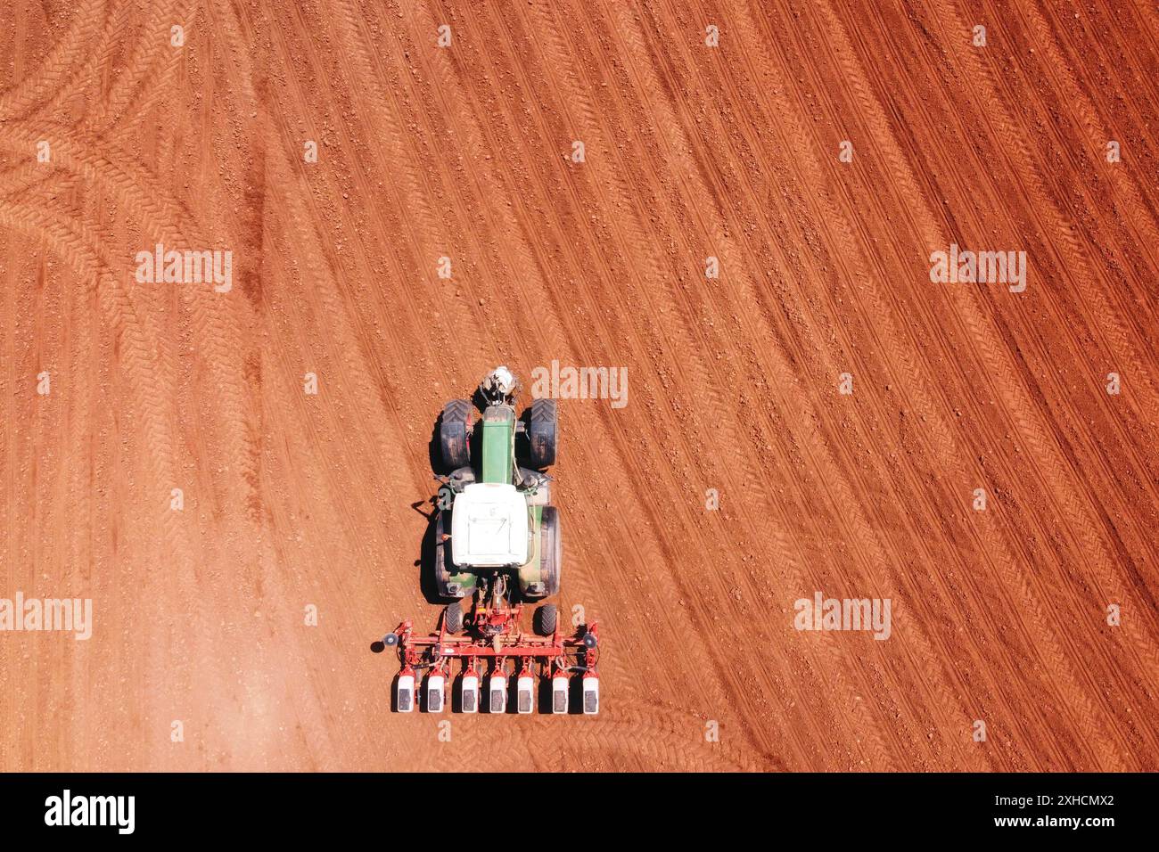 Farmer seeding, sowing crops at field with tractor.Sowing is the ...