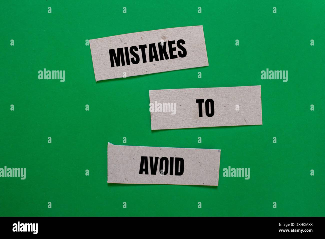 Mistakes to avoid message written on paper pieces with green background ...