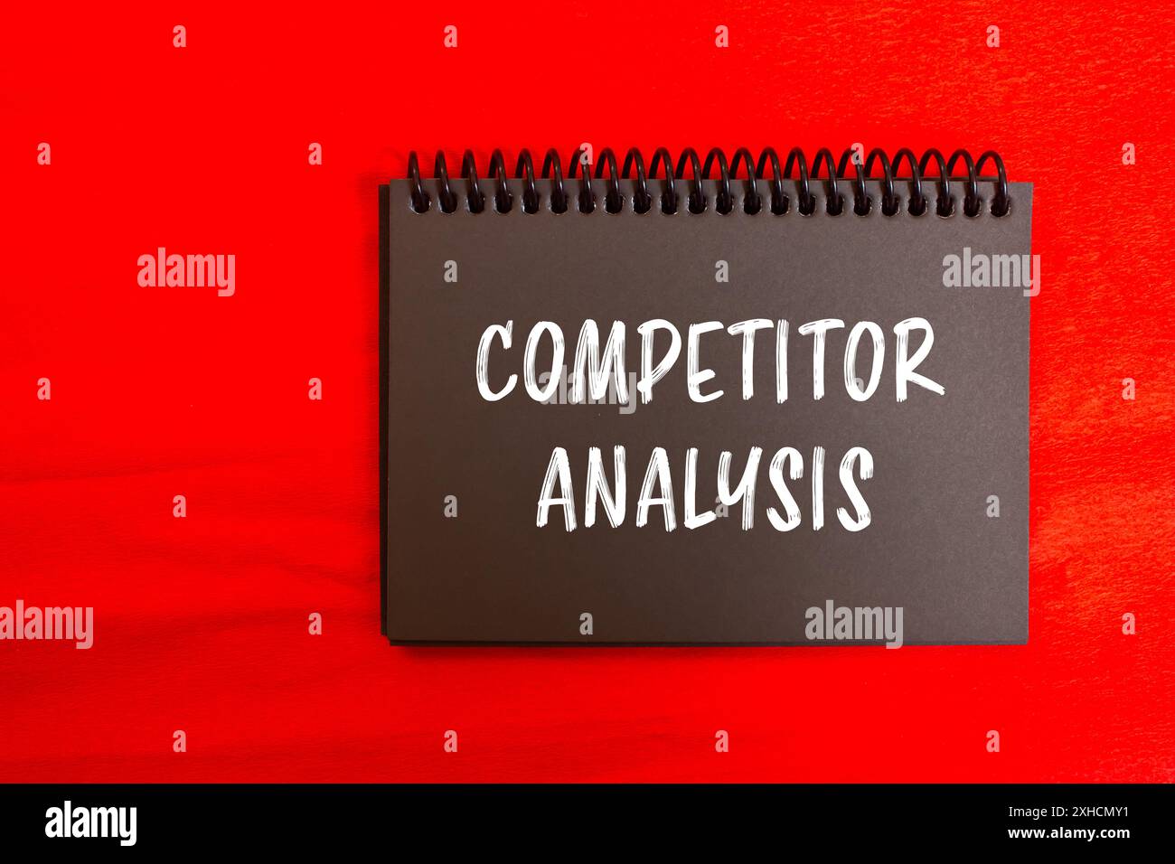 Competitor analysis message written on black notebook page with red ...