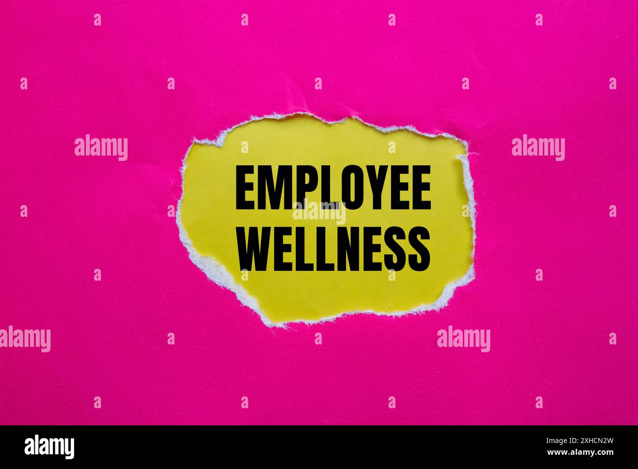 Employee wellness words written on ripped pink paper with yellow ...