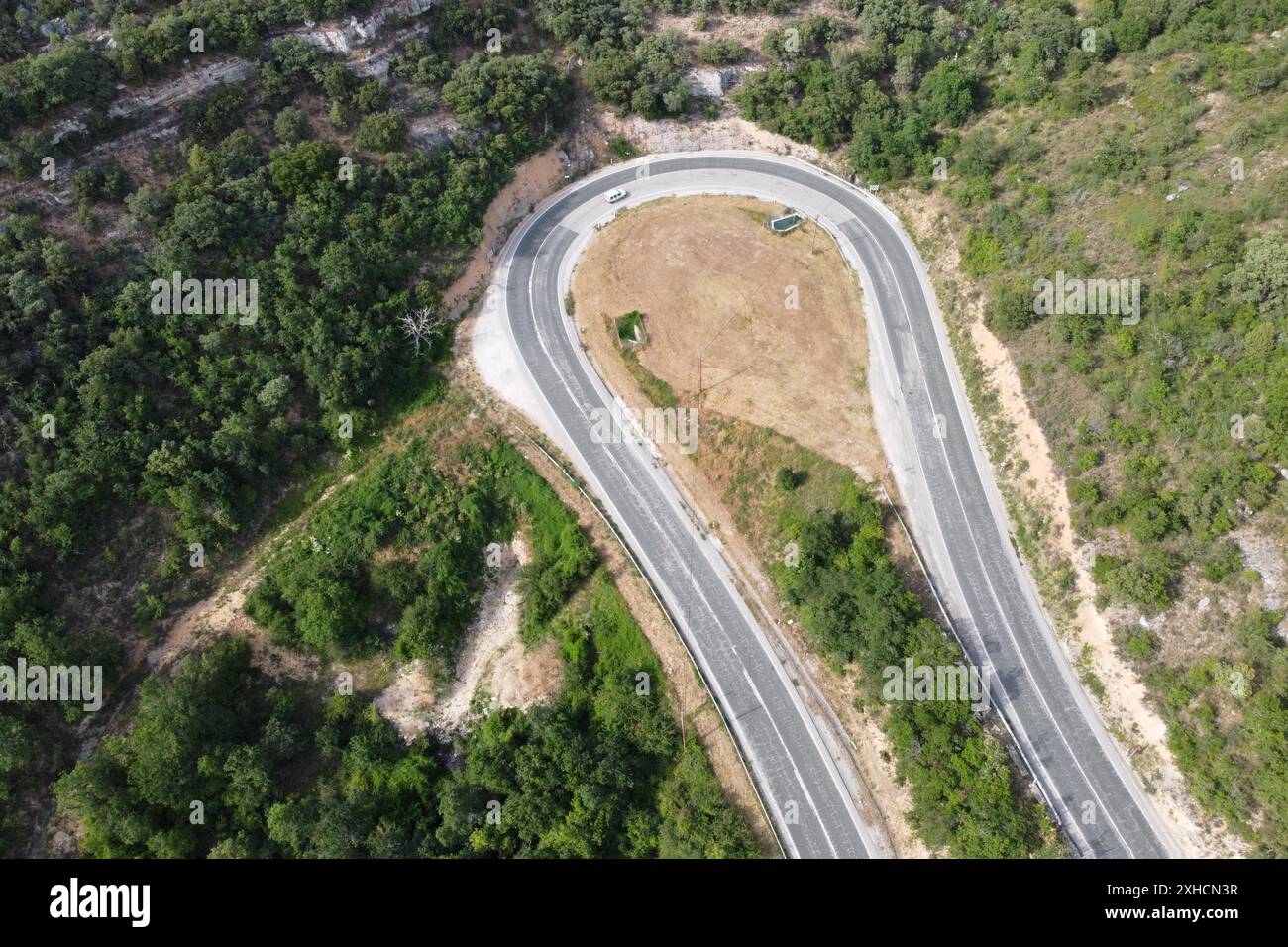 Aerial view of winding road in high mountain pass trough green pine ...