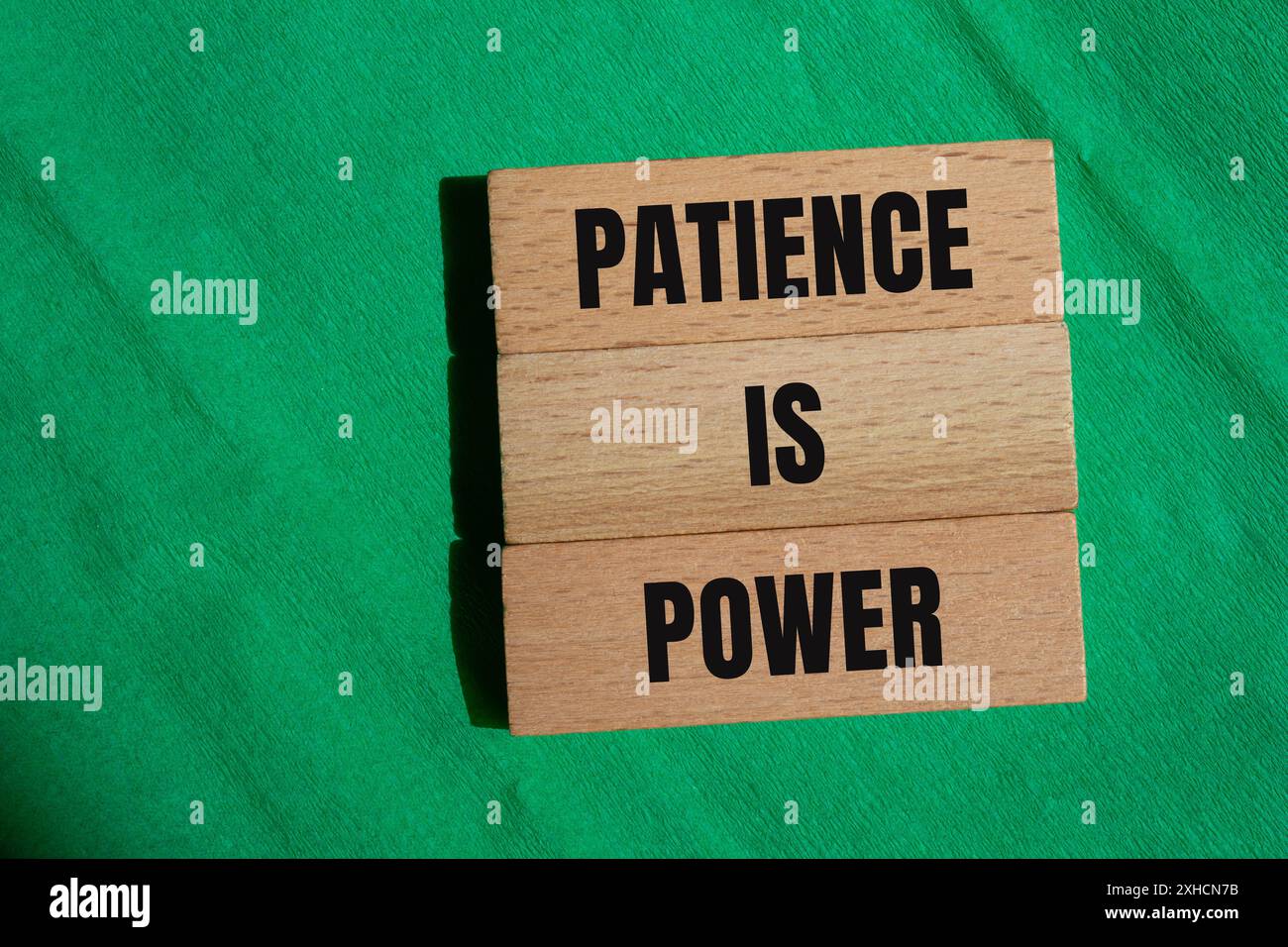 Patience is power words written on wooden blocks with green background ...