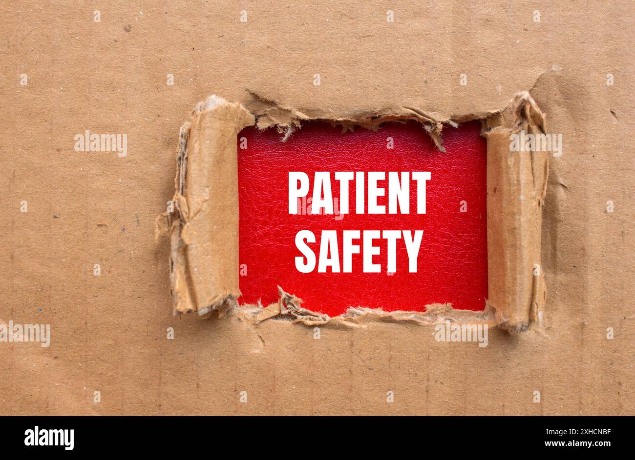 Patient safety message written on ripped cardboard paper with red ...