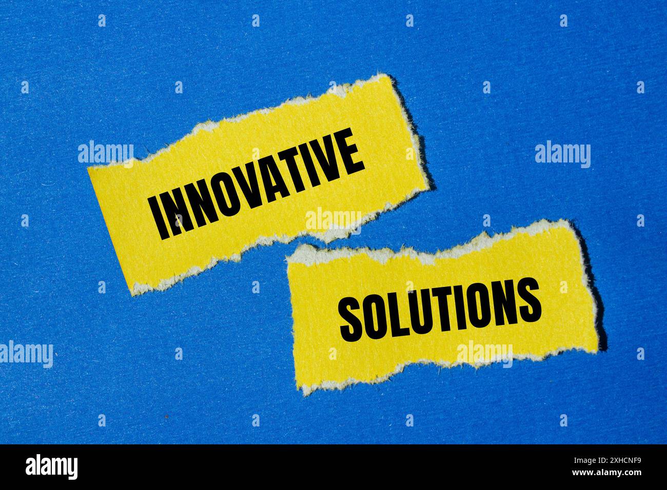 Innovative solutions message written on ripped yellow paper pieces with ...