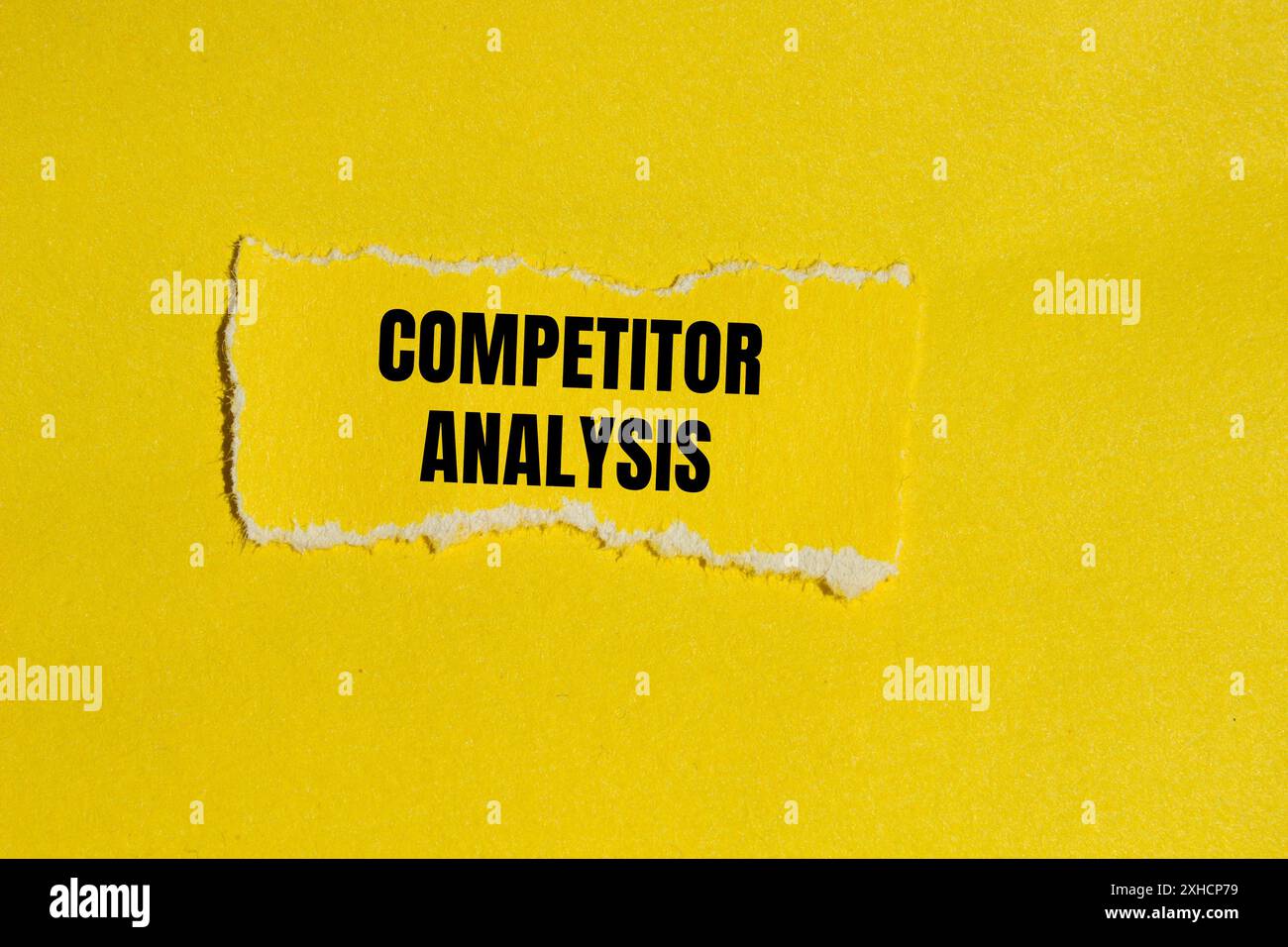 Competitor analysis message written on ripped paper piece with yellow ...