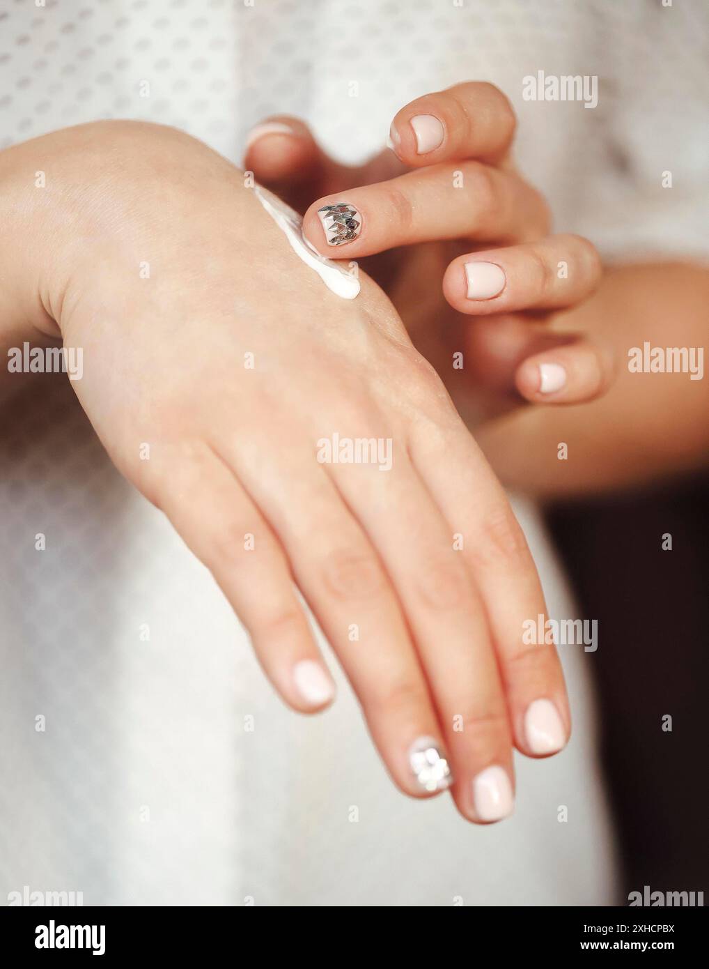 Unrecognizable female smearing cream on clean hands during skin care ...