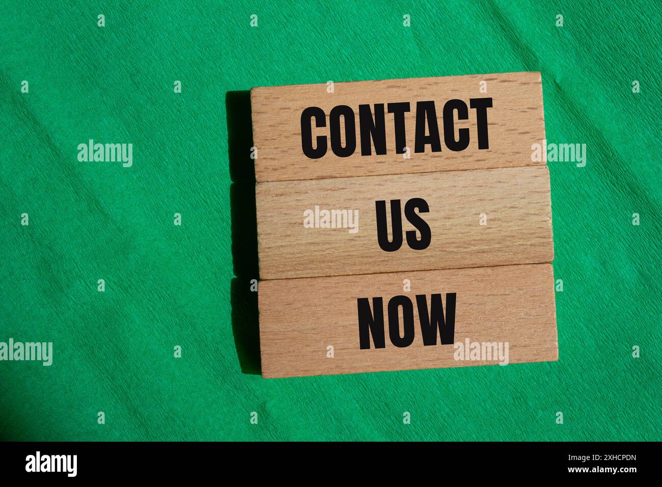 Contact us now words written on wooden blocks with green background ...