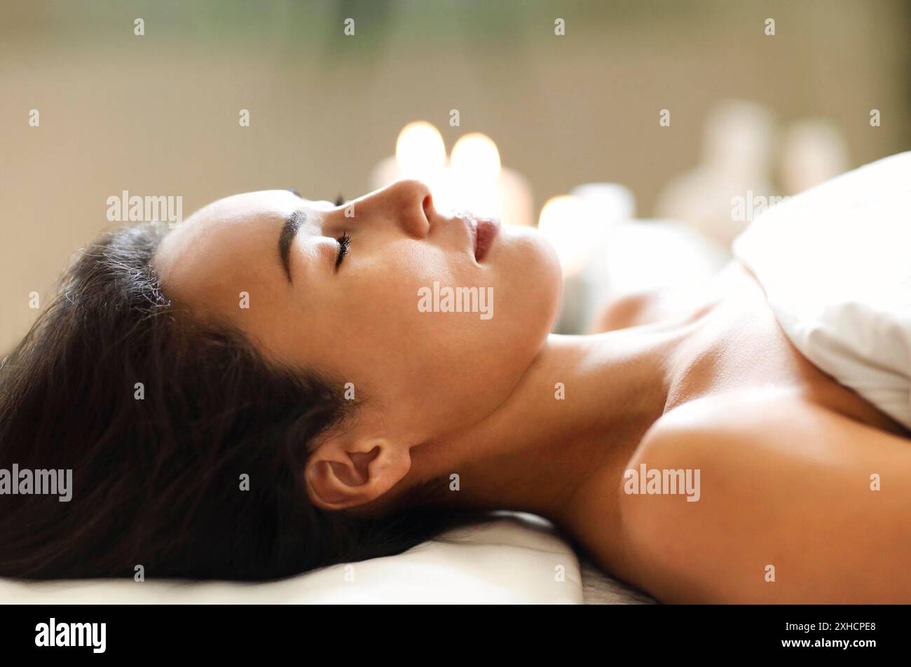 Side view of ethnic female client with closed eyes relaxing during spa session in salon Stock ...