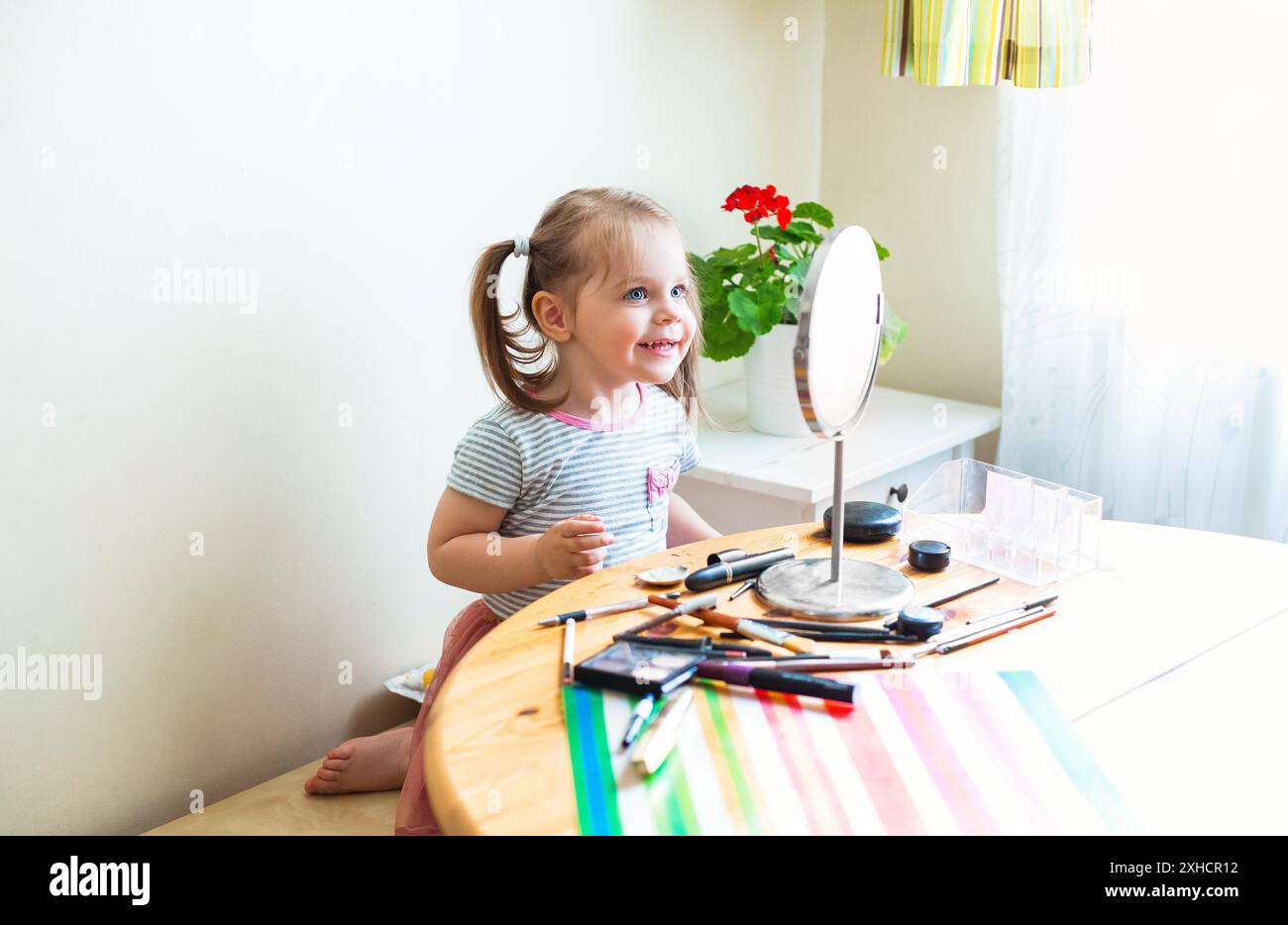 Adorable little child with dirty face playing with cosmetics and doing ...