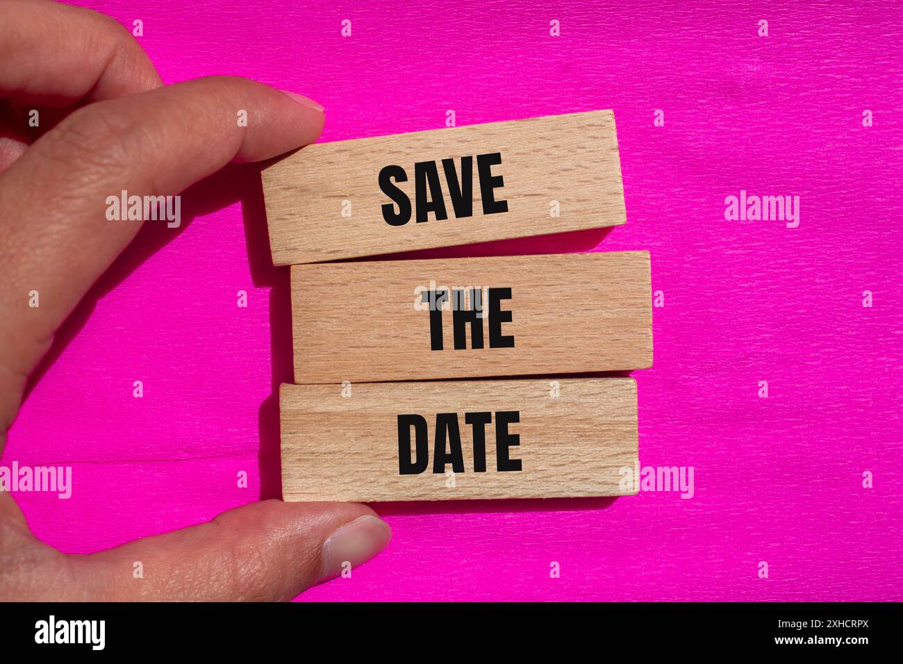 Save the date words written on wooden blocks with pink background ...