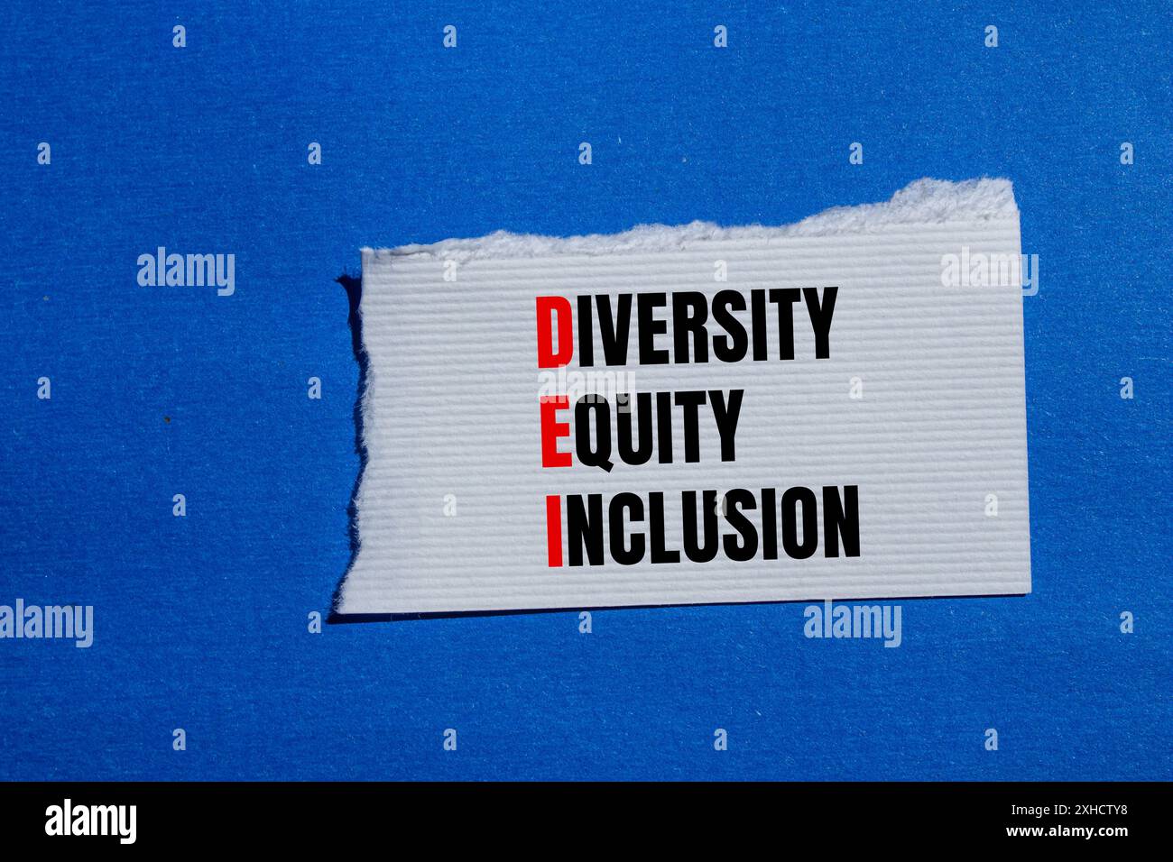 Diversity, equity and inclusion words written on ripped white paper ...
