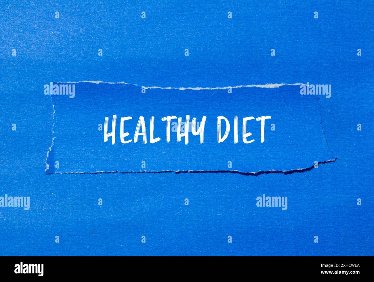 Healthy diet message written on ripped paper piece with blue background ...