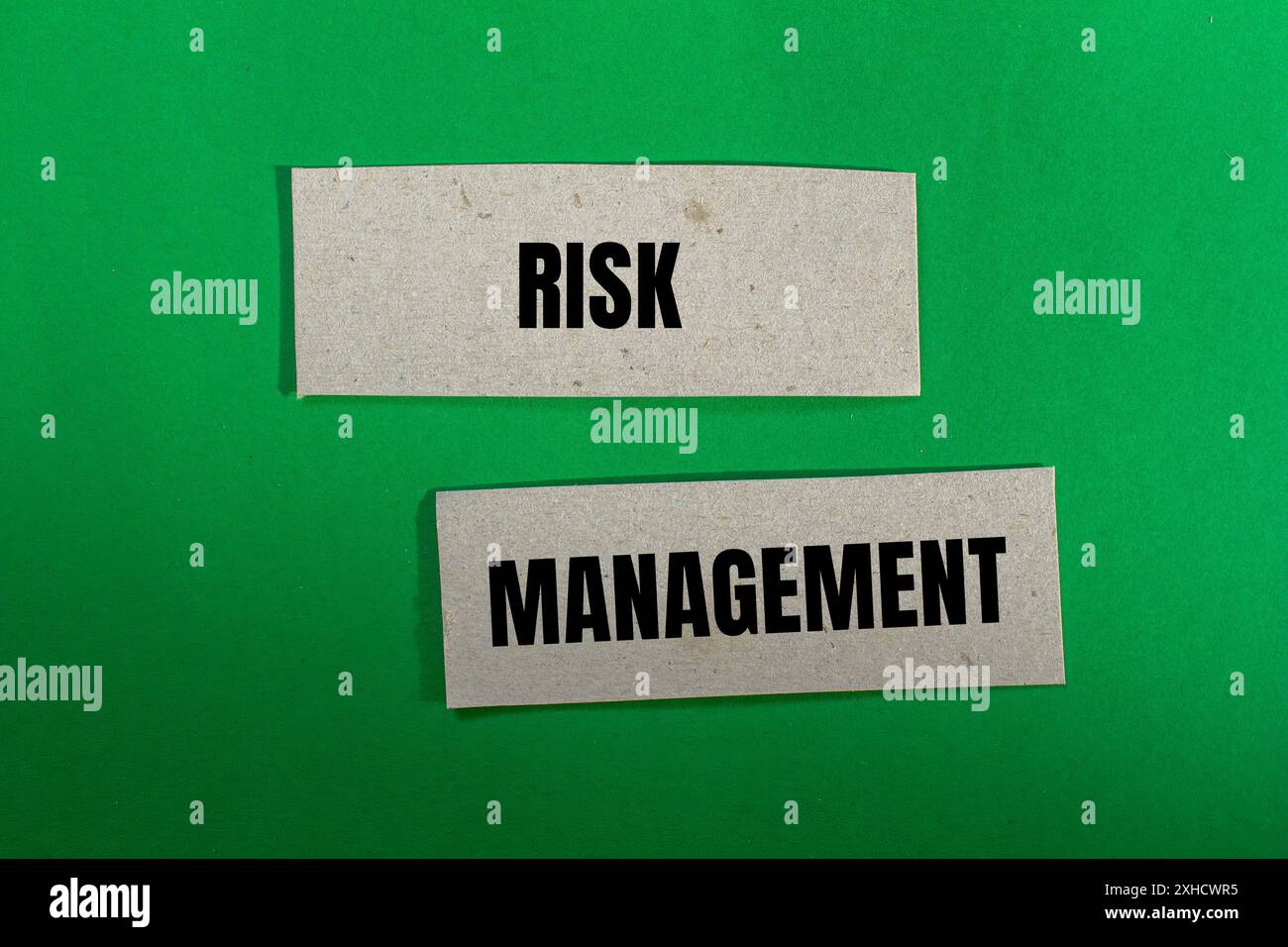 Risk management message written on paper pieces with green background ...