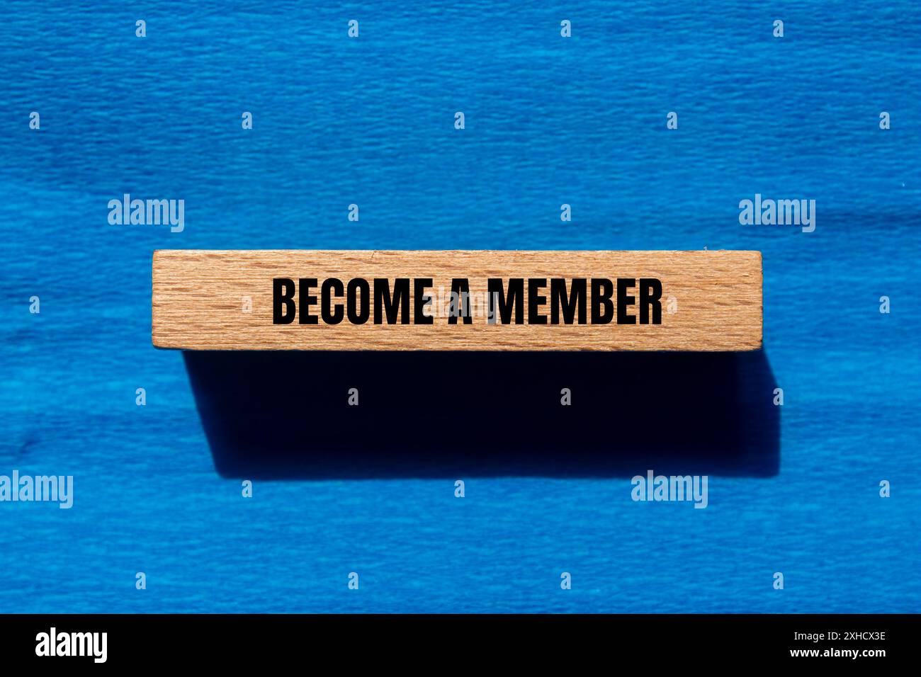 Become a member message written on wooden block with blue background ...