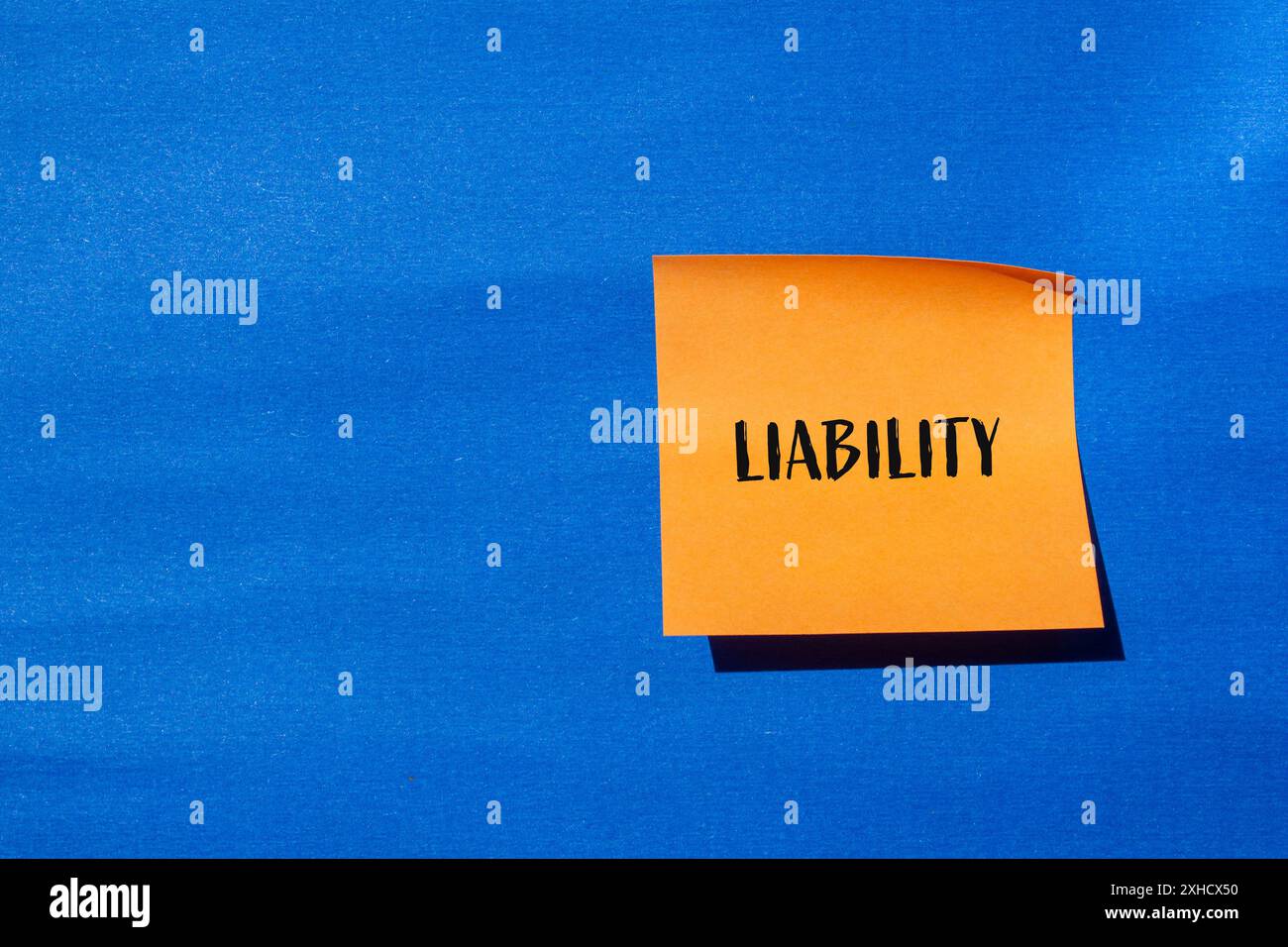 Liability message written on orange paper with blue background ...